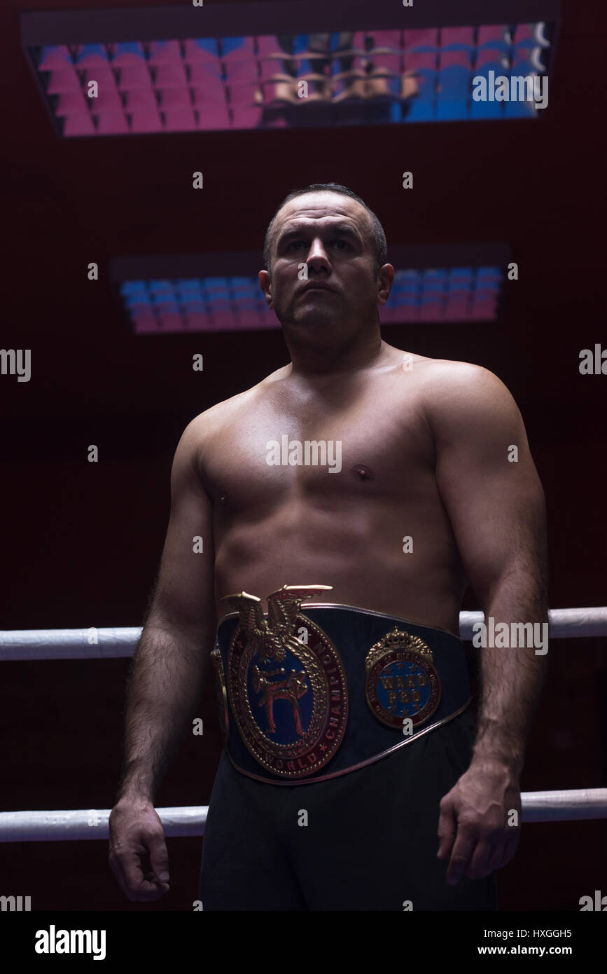 portrait of muscular professional kick boxer with his championship belt ...