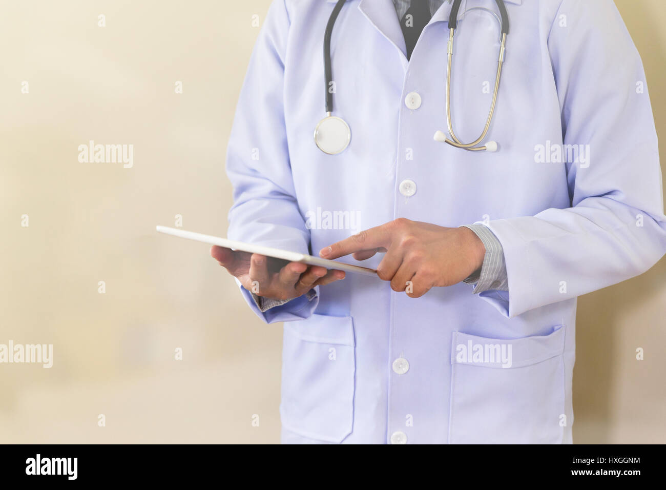 medical doctor in white lab coat using his tablet computer at work ...