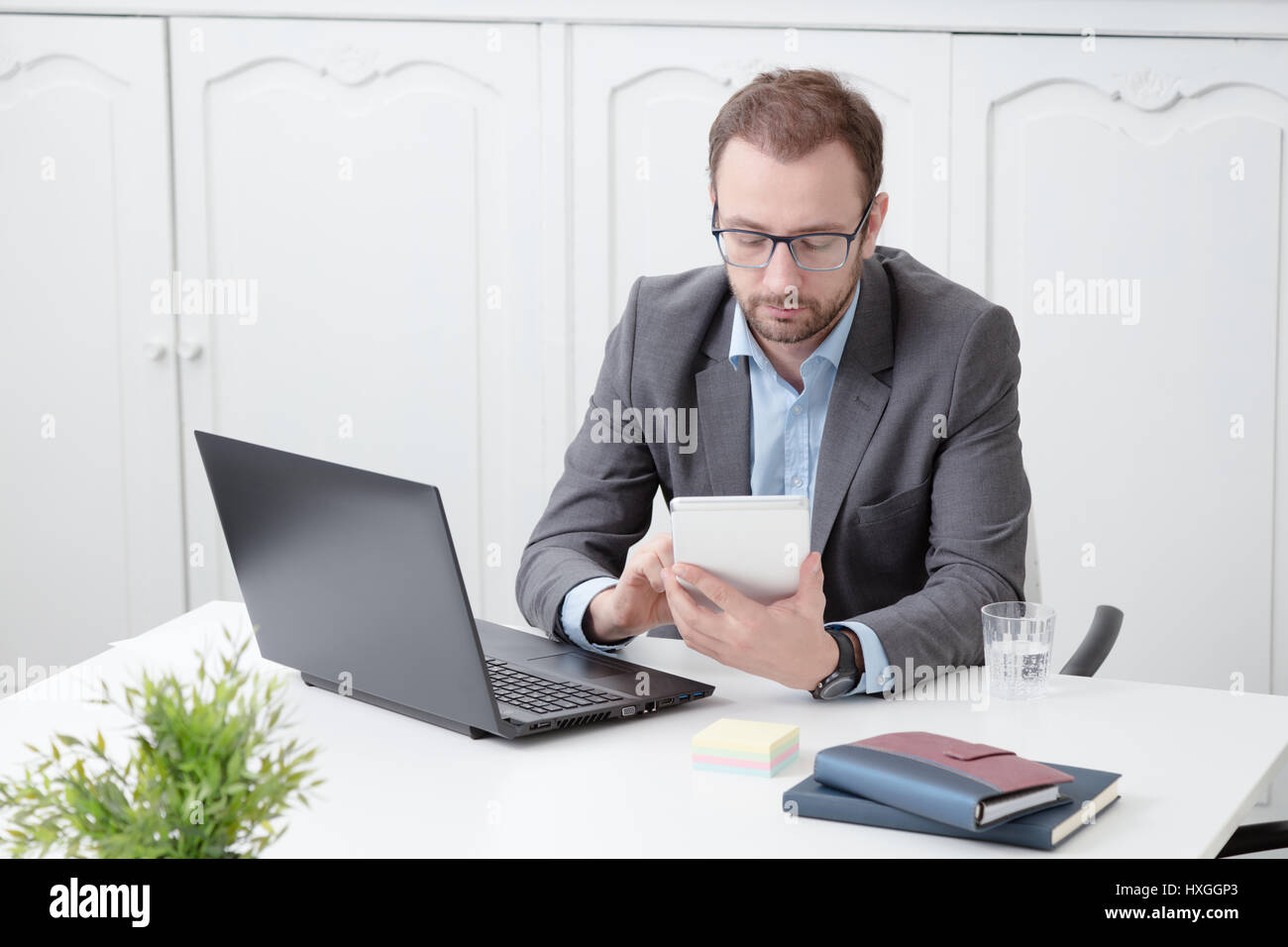 Young professional working on digital tablet device at the desk in the ...