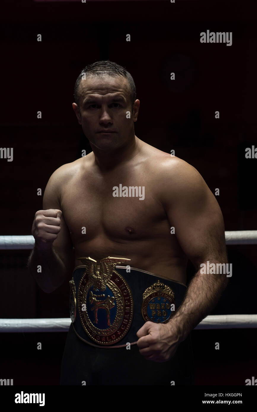 portrait of muscular professional kick boxer with his championship belt ...