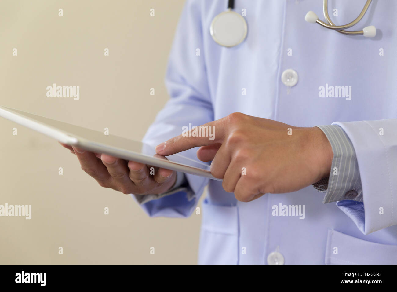 medical doctor in white lab coat using his tablet computer at work ...