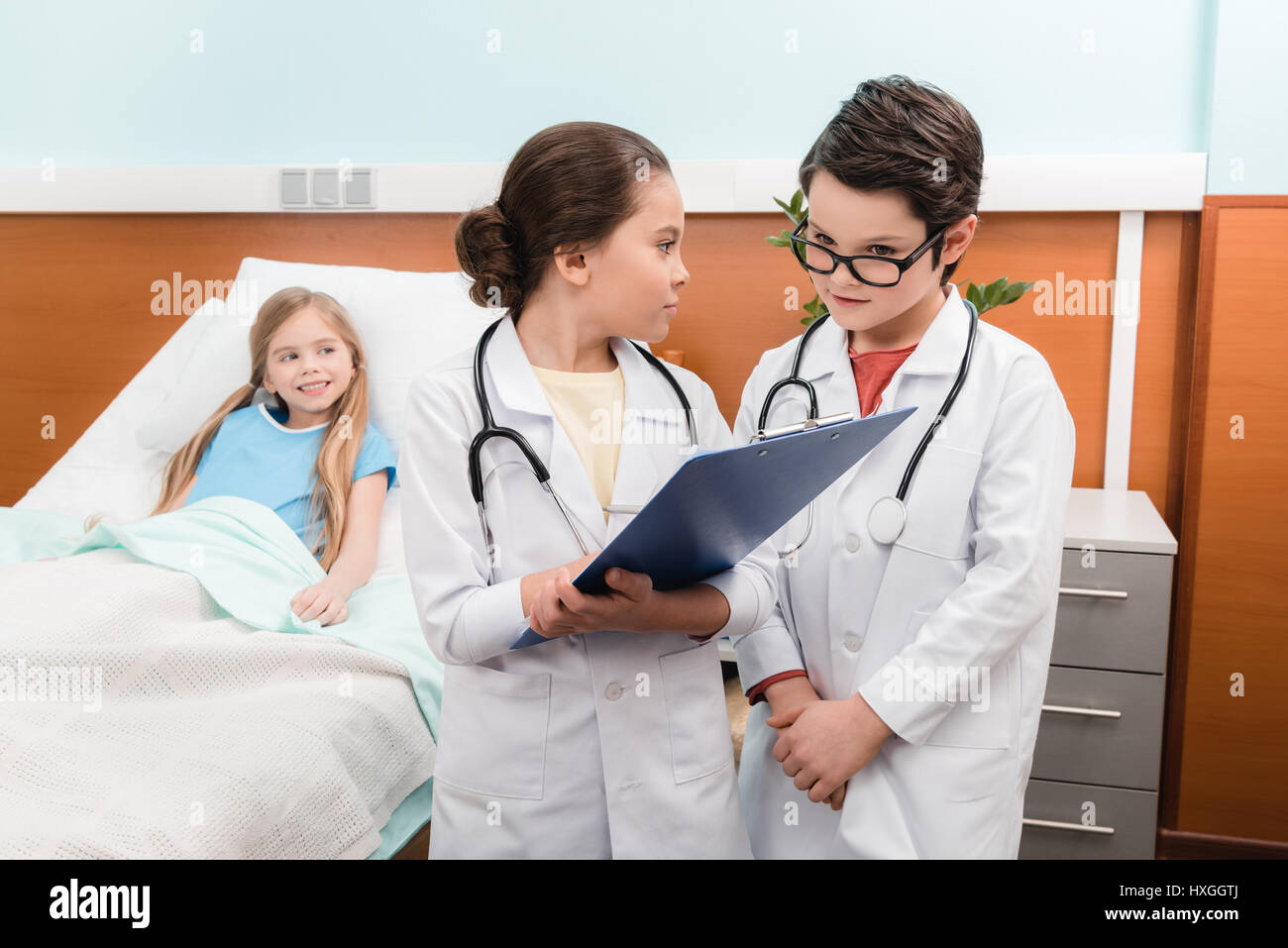Kids with stethoscopes and clipboard playing doctors with smiling ...