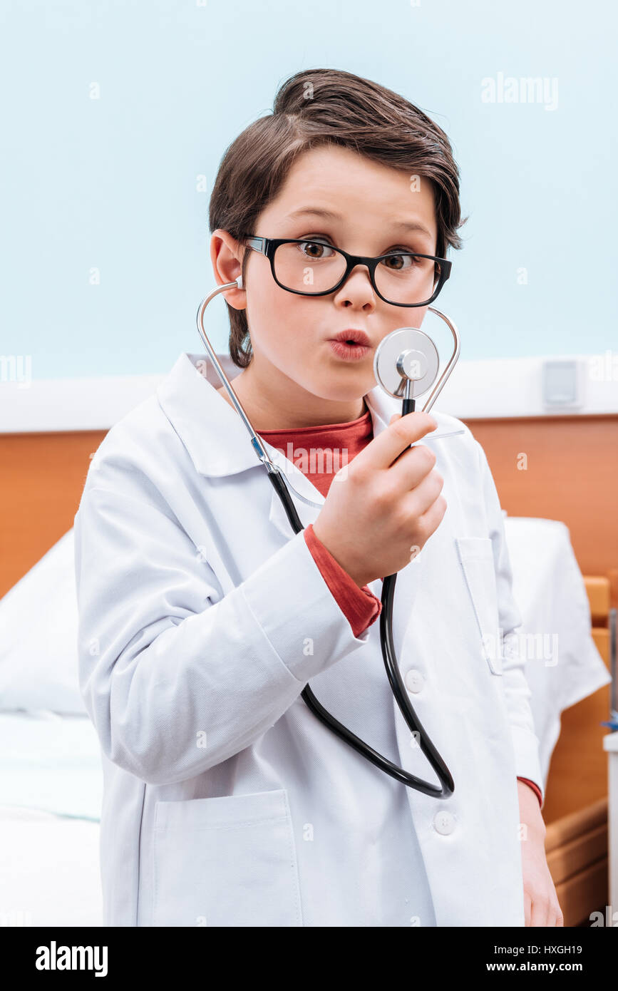 Surprised boy doctor in medical uniform with stethoscope looking at ...
