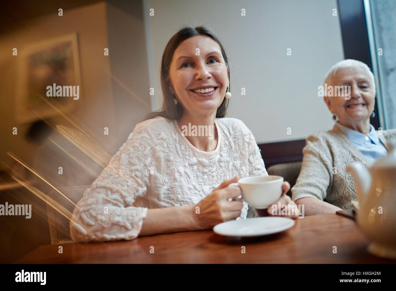 Friendly mature woman having drink in cafe Stock Photo - Alamy