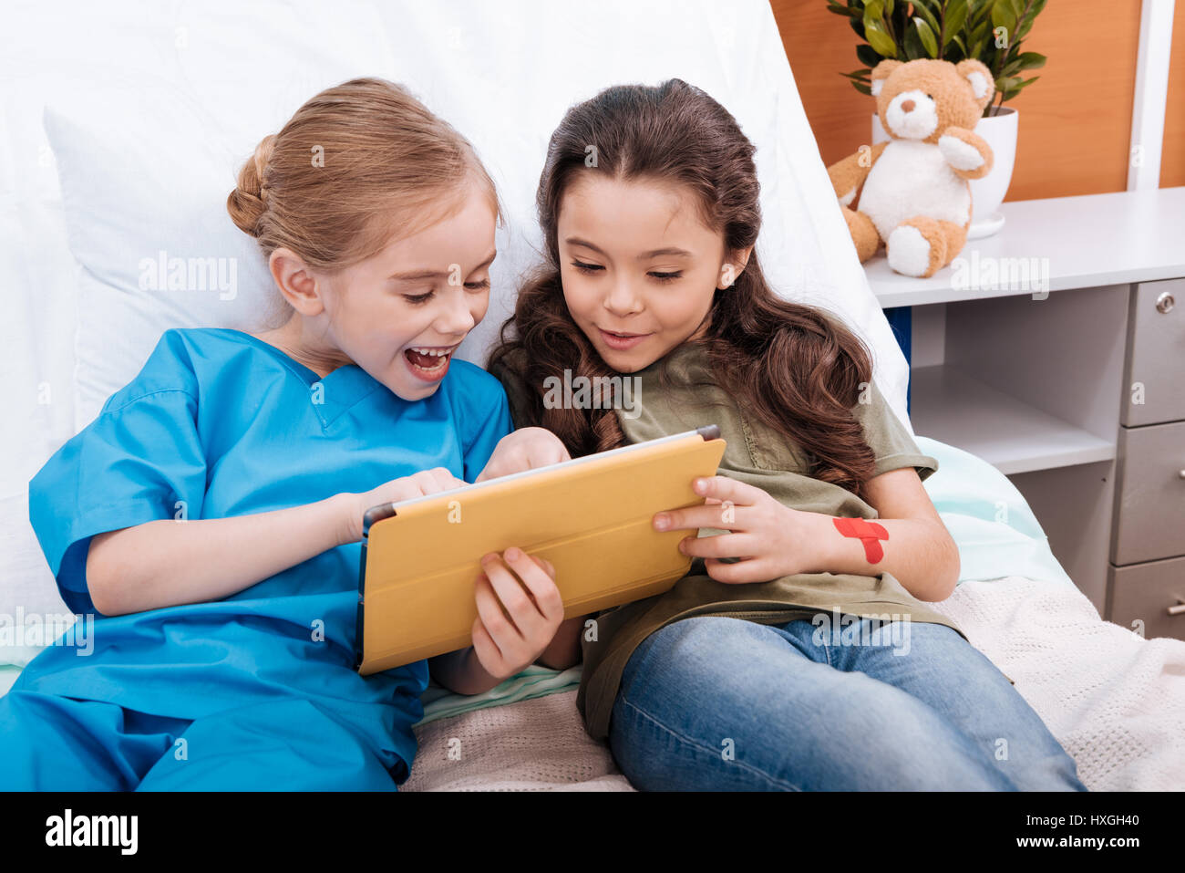 portrait of girls nurse and patient using digital tablet while lying on ...
