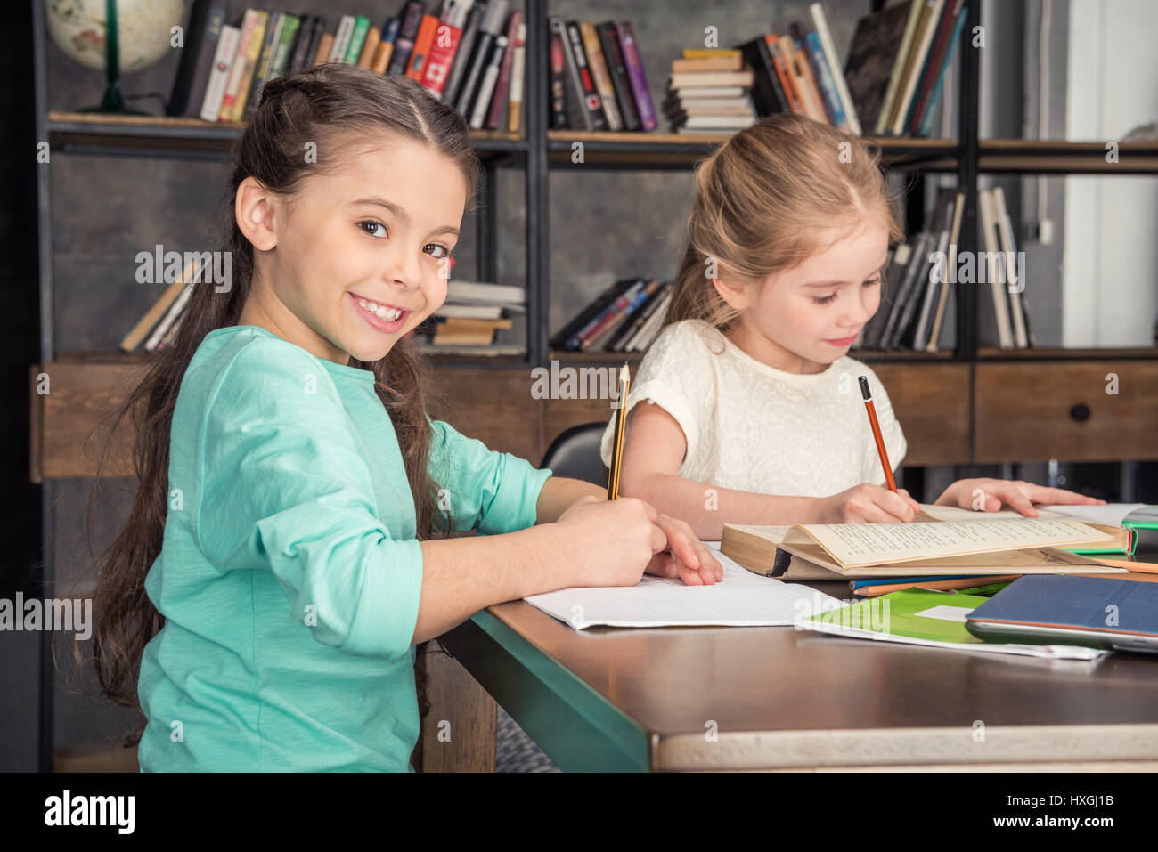 side view of classmates doing homework together in library Stock Photo ...