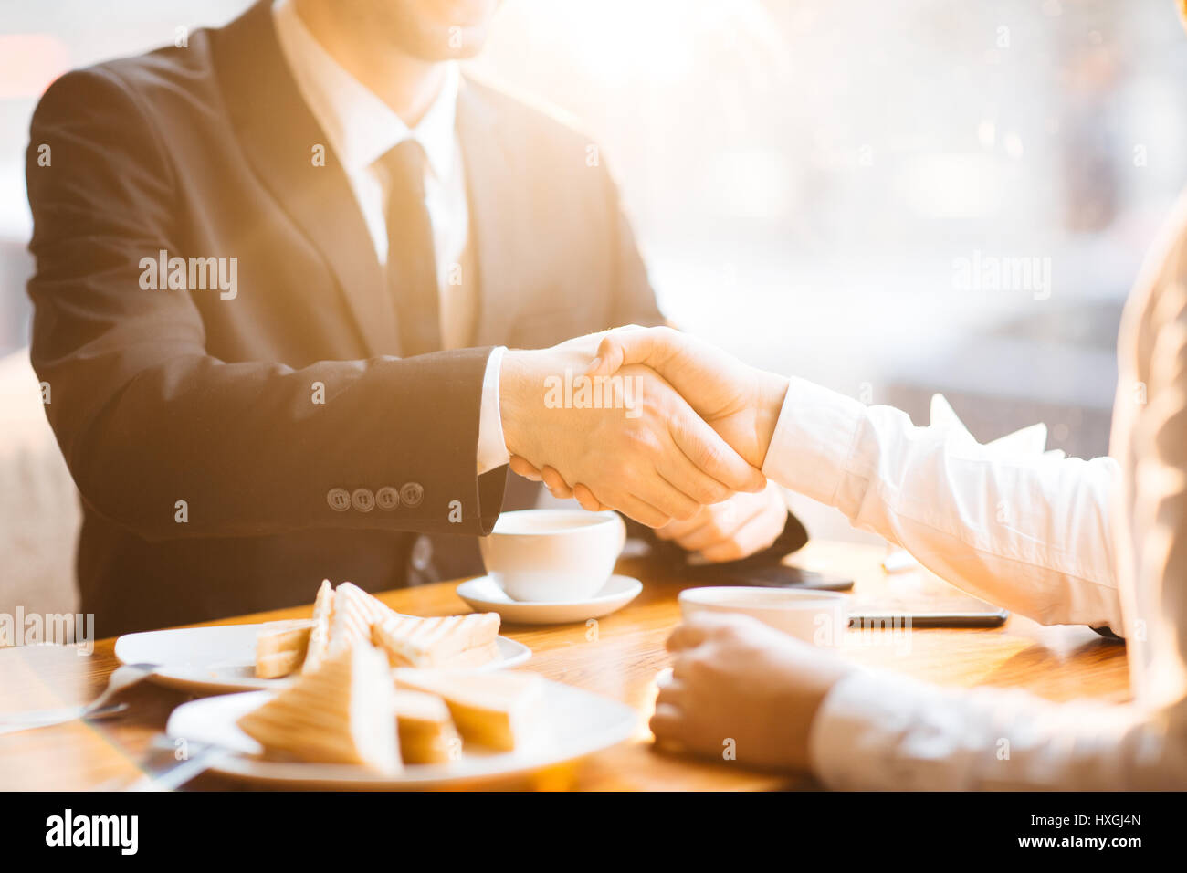 Handshake of businessmen during lunch break Stock Photo - Alamy
