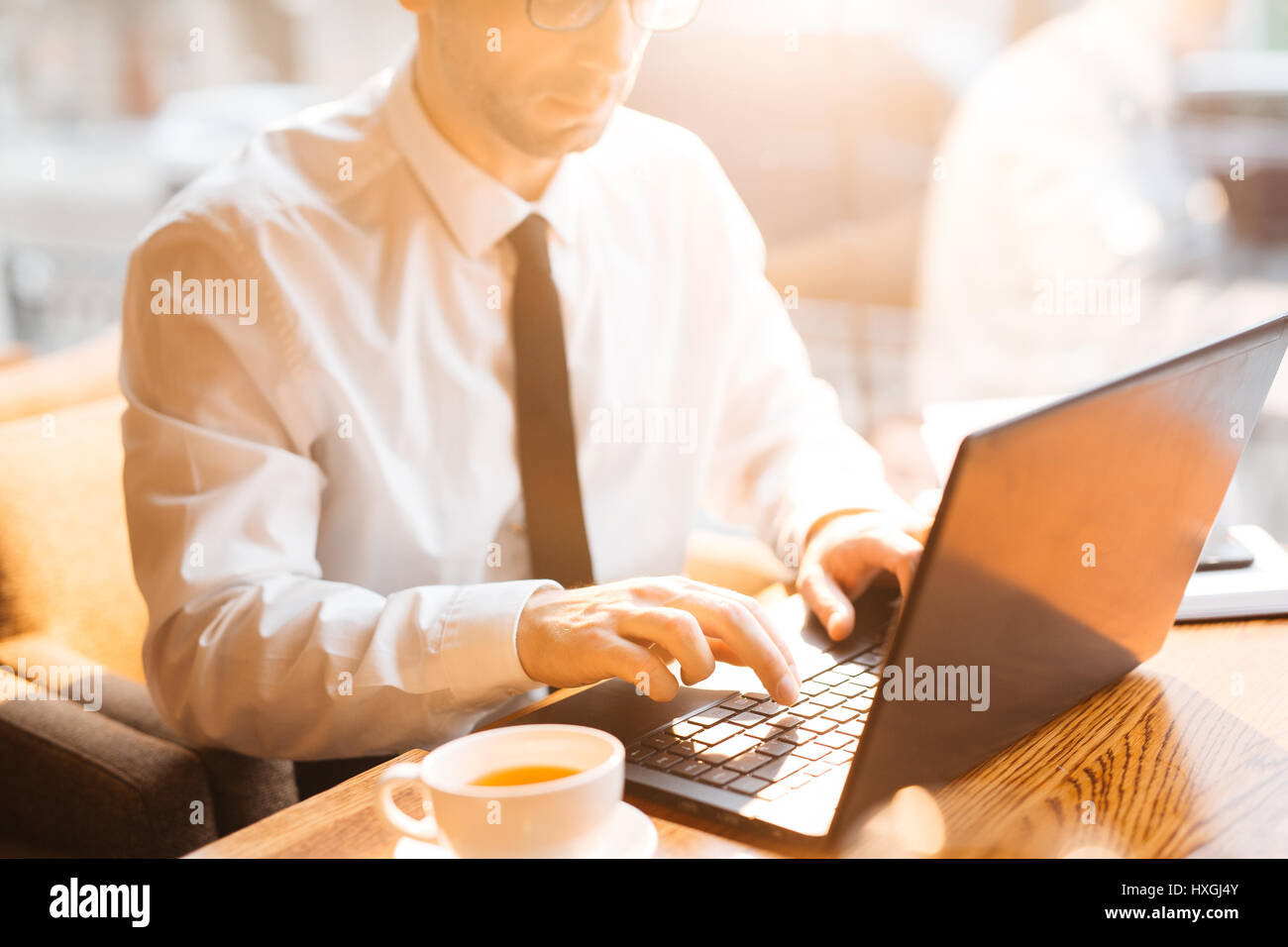 Businessman typing during coffee-break on sunny day Stock Photo - Alamy