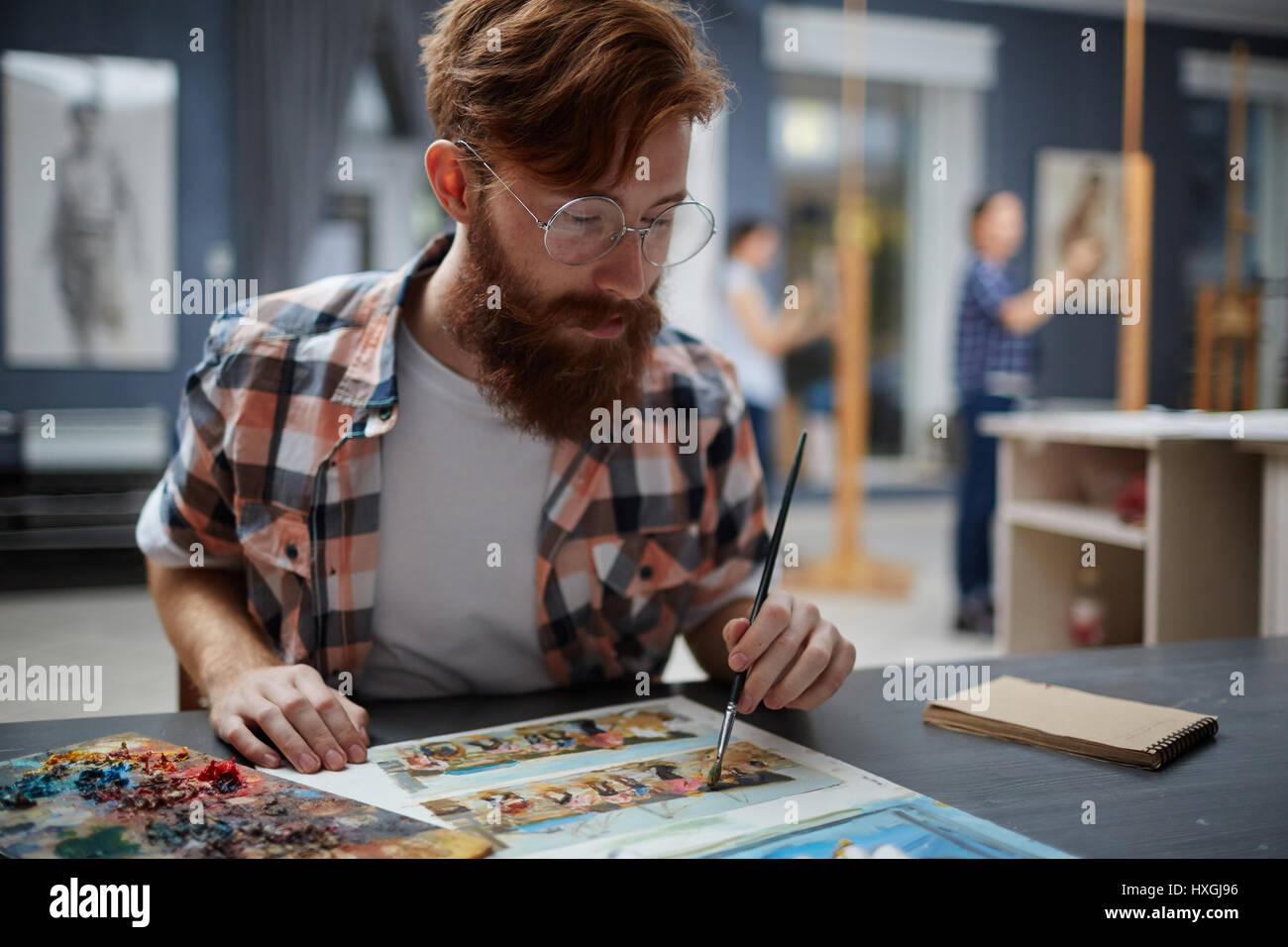 Young man painting with acrylic paints in art-school Stock Photo - Alamy