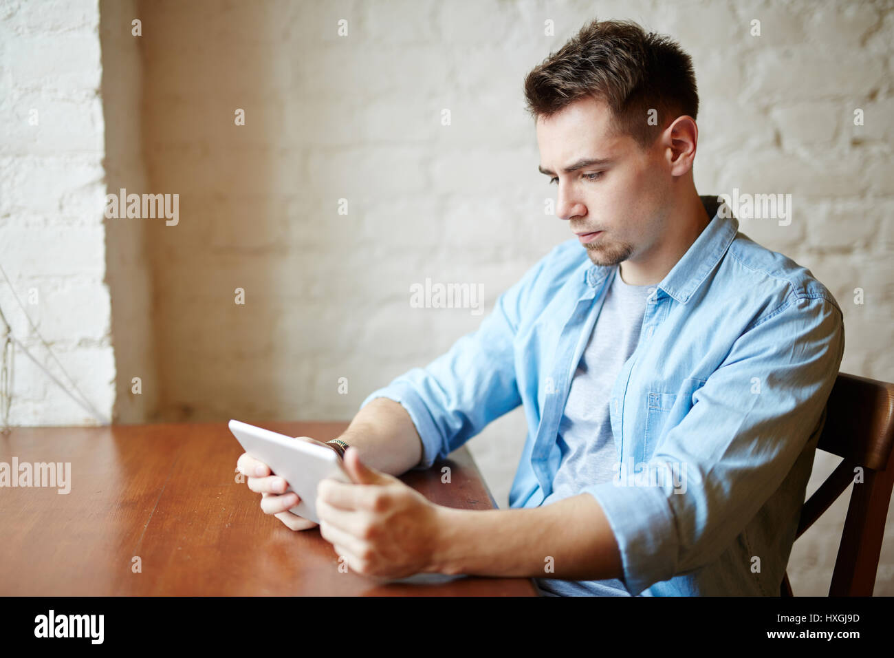 Side view portrait of modern young man using portable digital tablet ...