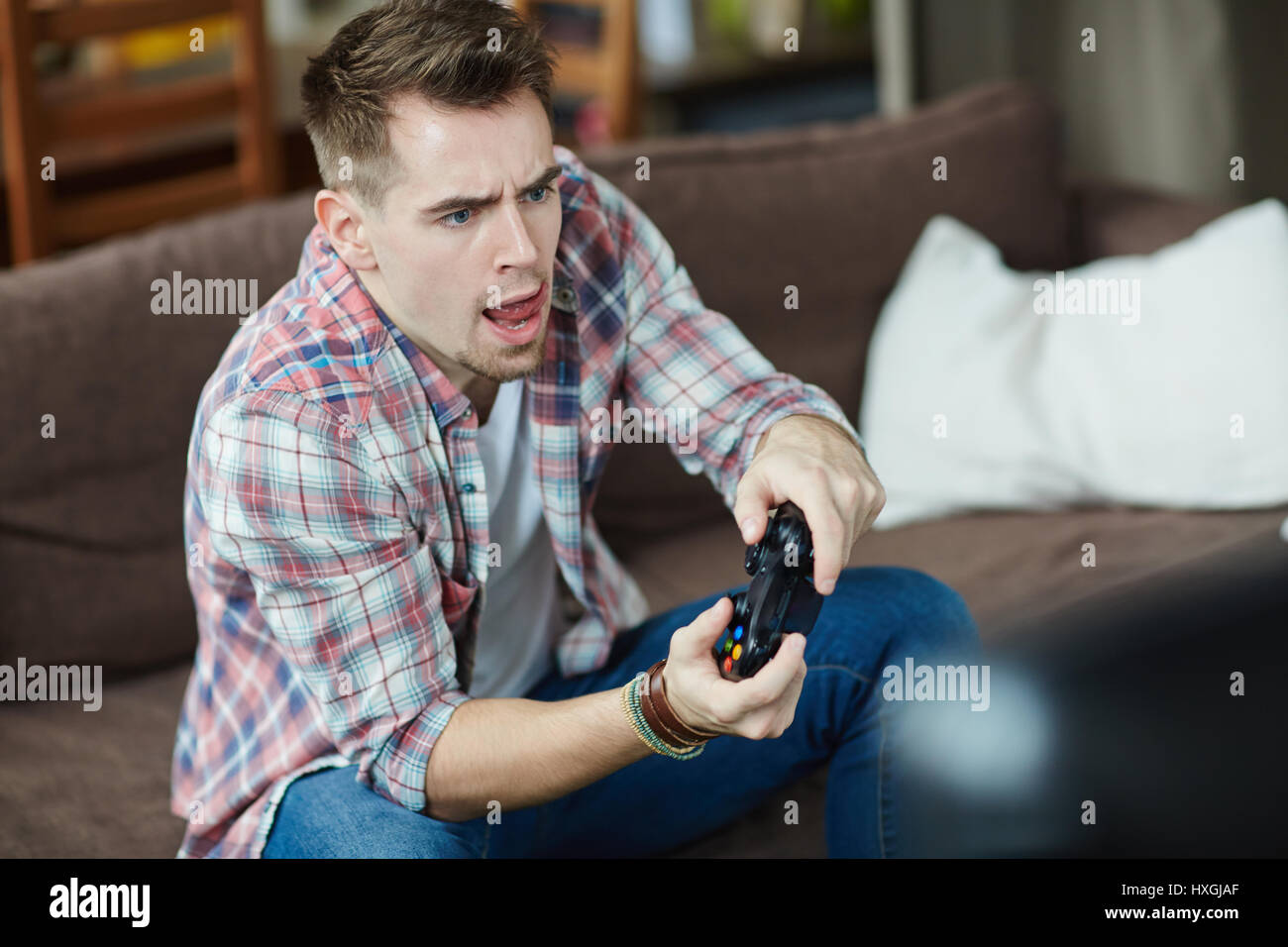 Portrait emotional adult man playing video game holding wireless ...