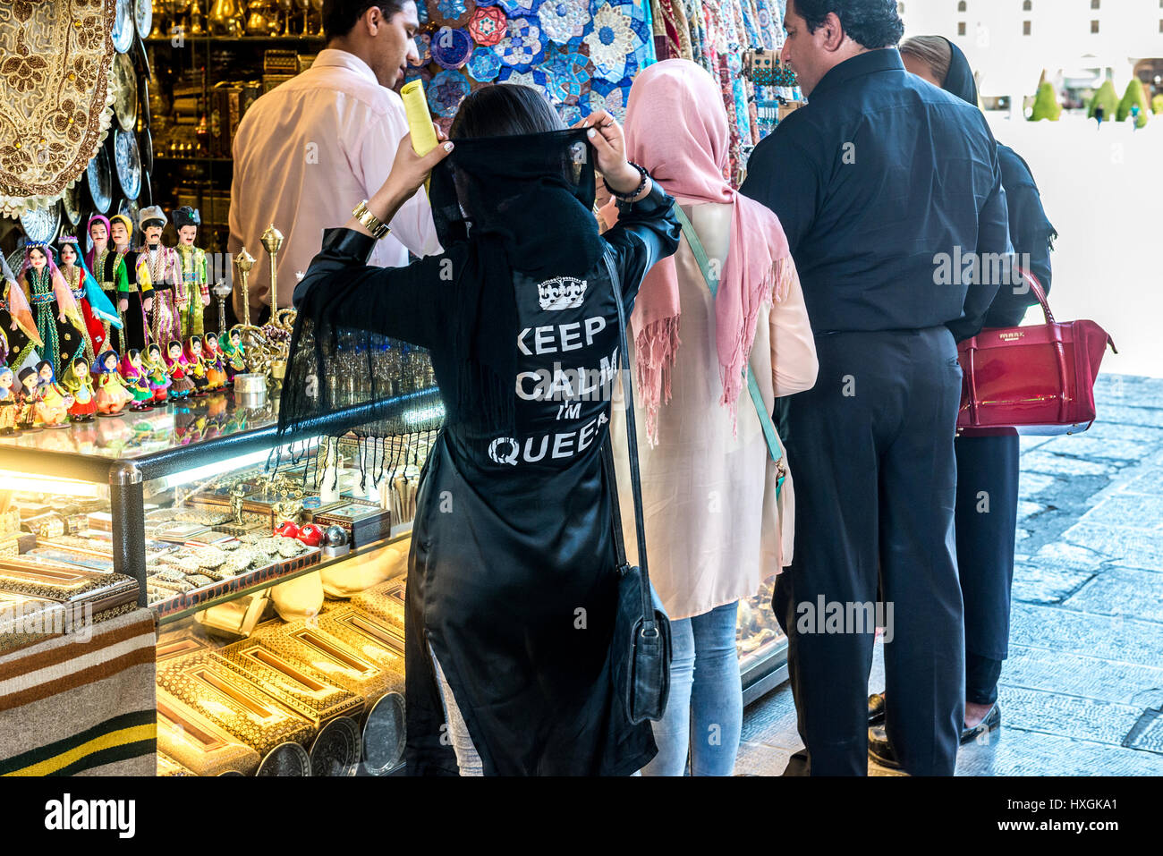 Young Iranian woman with "Keep Calm, I'm queen" slogan on her back on ...