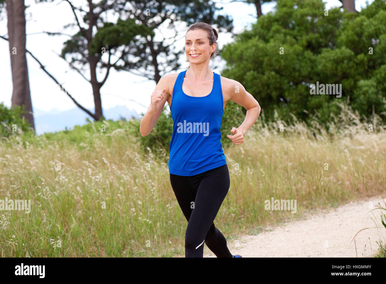 Portrait of smiling attractive woman speed walking Stock Photo - Alamy