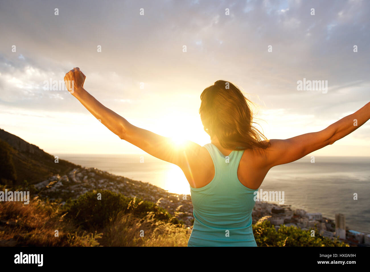Portrait of woman from behind stretching out her arms in front of ...