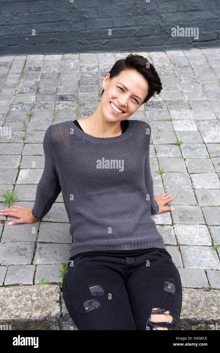 Portrait of a cool young woman sitting outside Stock Photo - Alamy