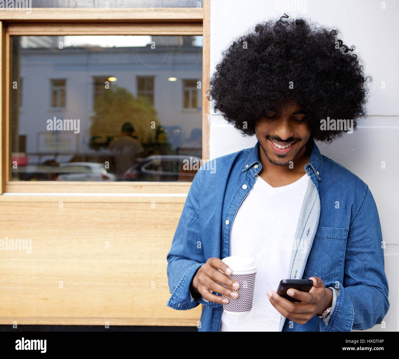 Portrait of a cool modern guy standing outside using cell phone Stock ...