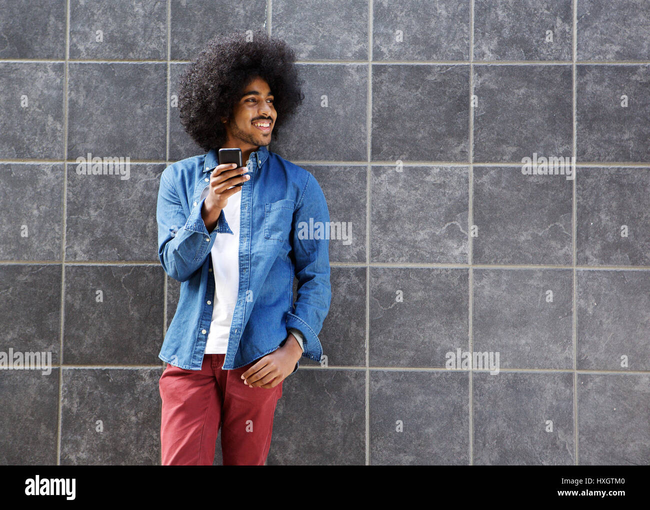 Portrait of a cool guy with afro using cellphone Stock Photo - Alamy