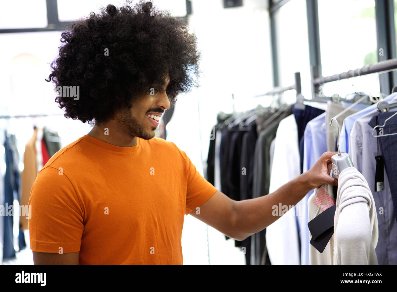 Young guy looking at clothes in store Stock Photo - Alamy