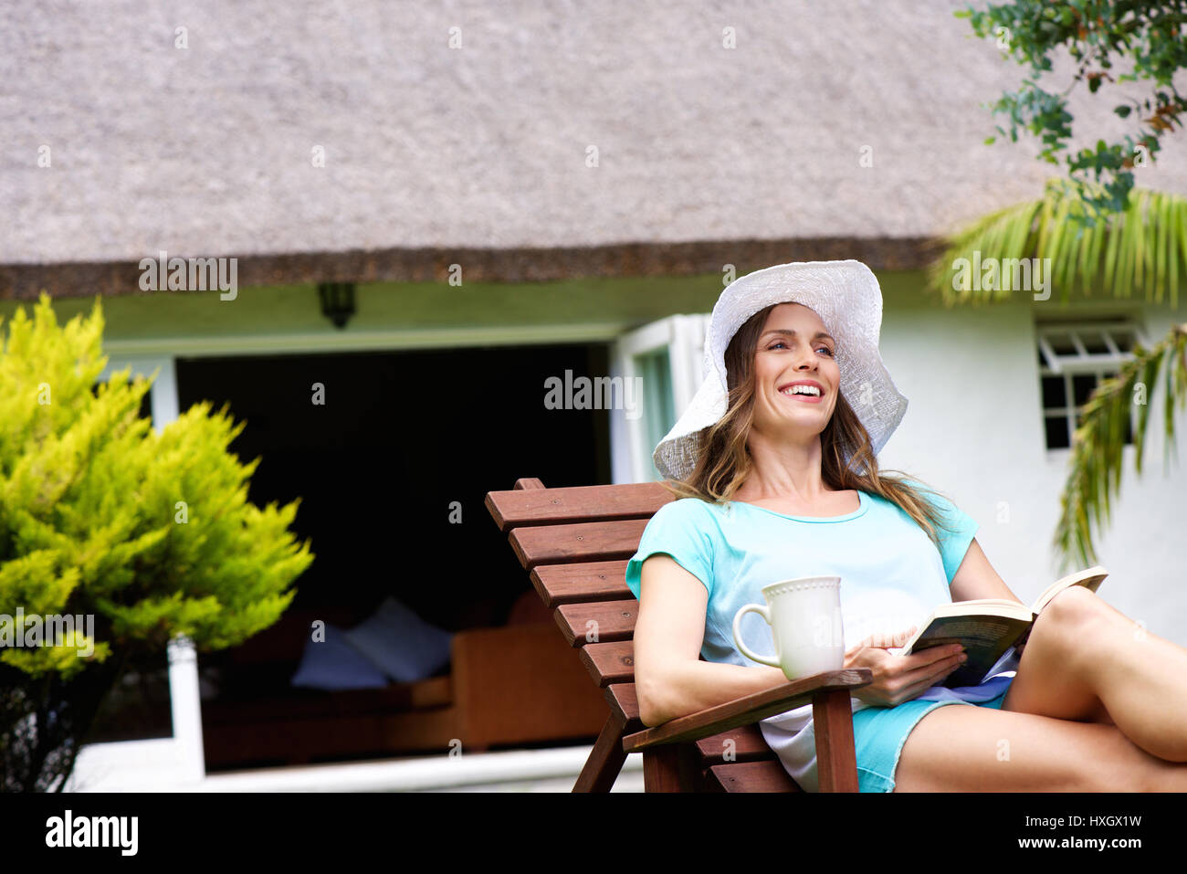 Happy woman sitting outside hi-res stock photography and images - Alamy