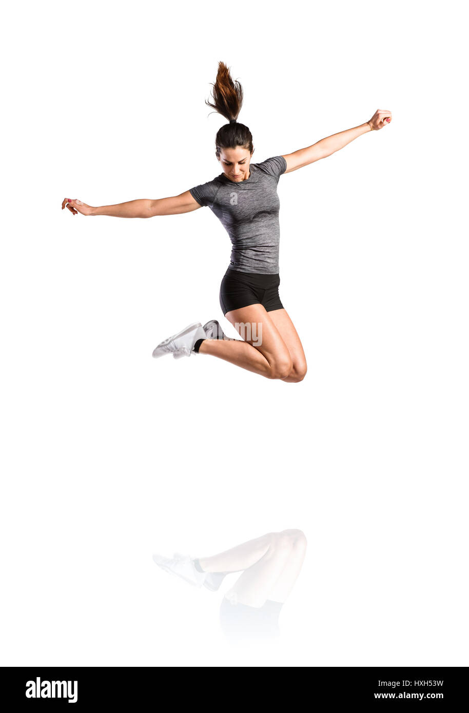 Young fitness woman jumping high. Studio shot, isolated Stock Photo - Alamy