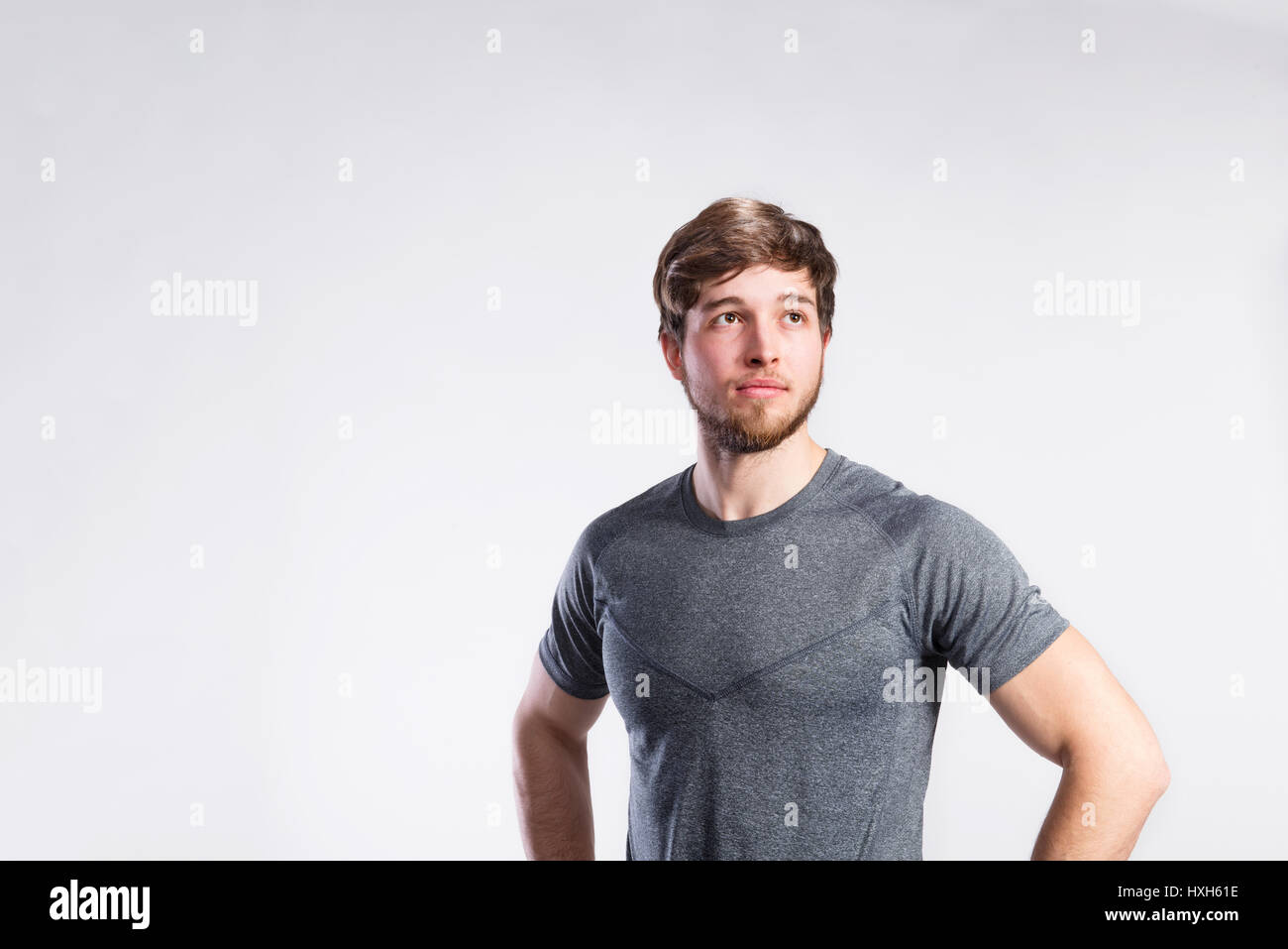 Handsome fitness man in gray t-shirt, studio shot Stock Photo - Alamy
