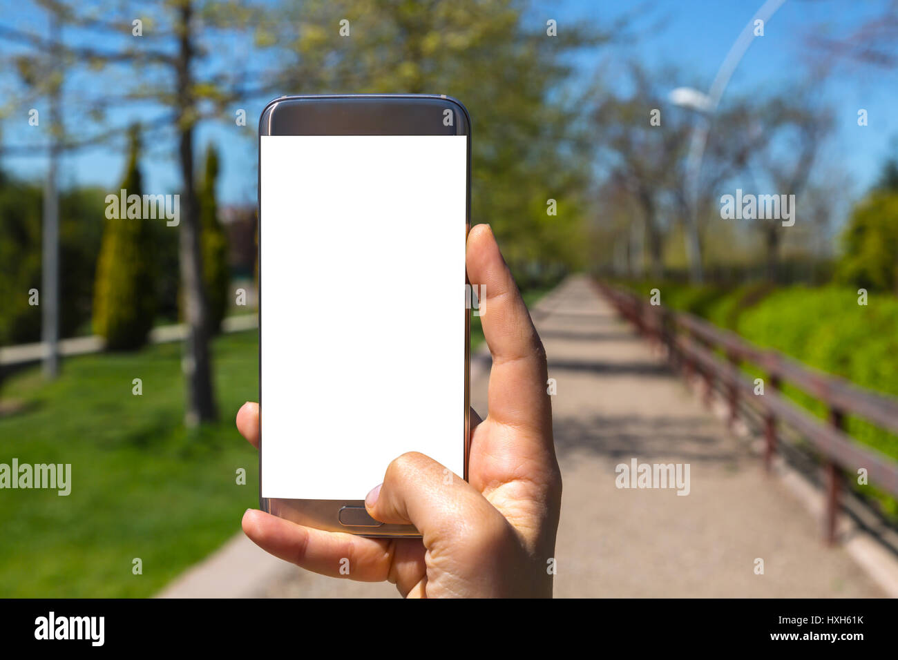 Front view of hand holding black smartphone with white blank copy space ...