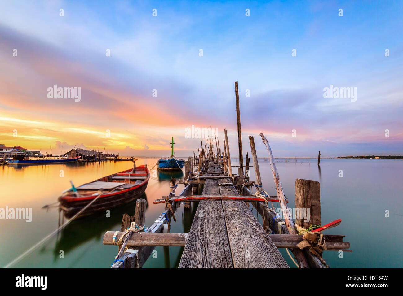Old wood bridge for small fishing boat in the sea with sunset Stock ...