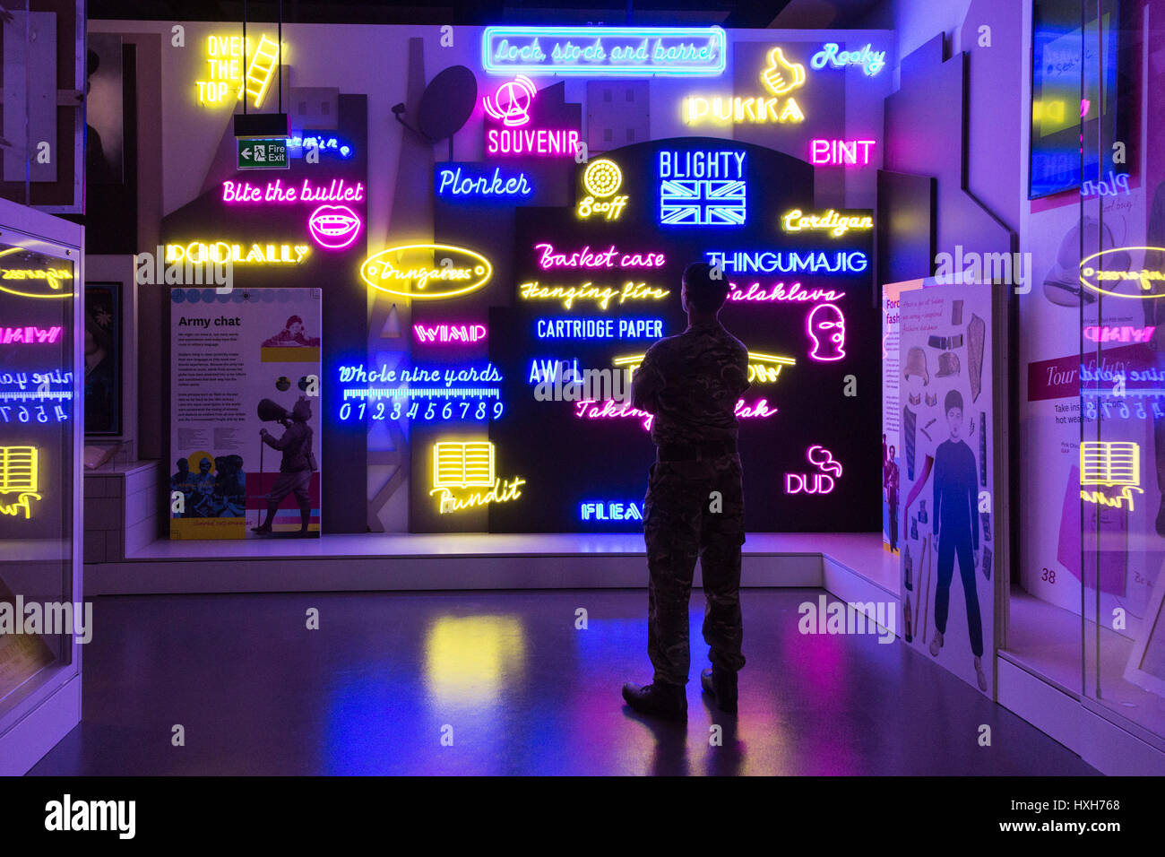London, UK. 28 March 2017. A soldier stands in front of neon lights ...