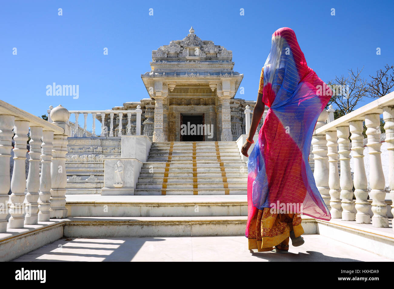Lady in a vibrant sari walks towards a Jain Temple Stock Photo - Alamy