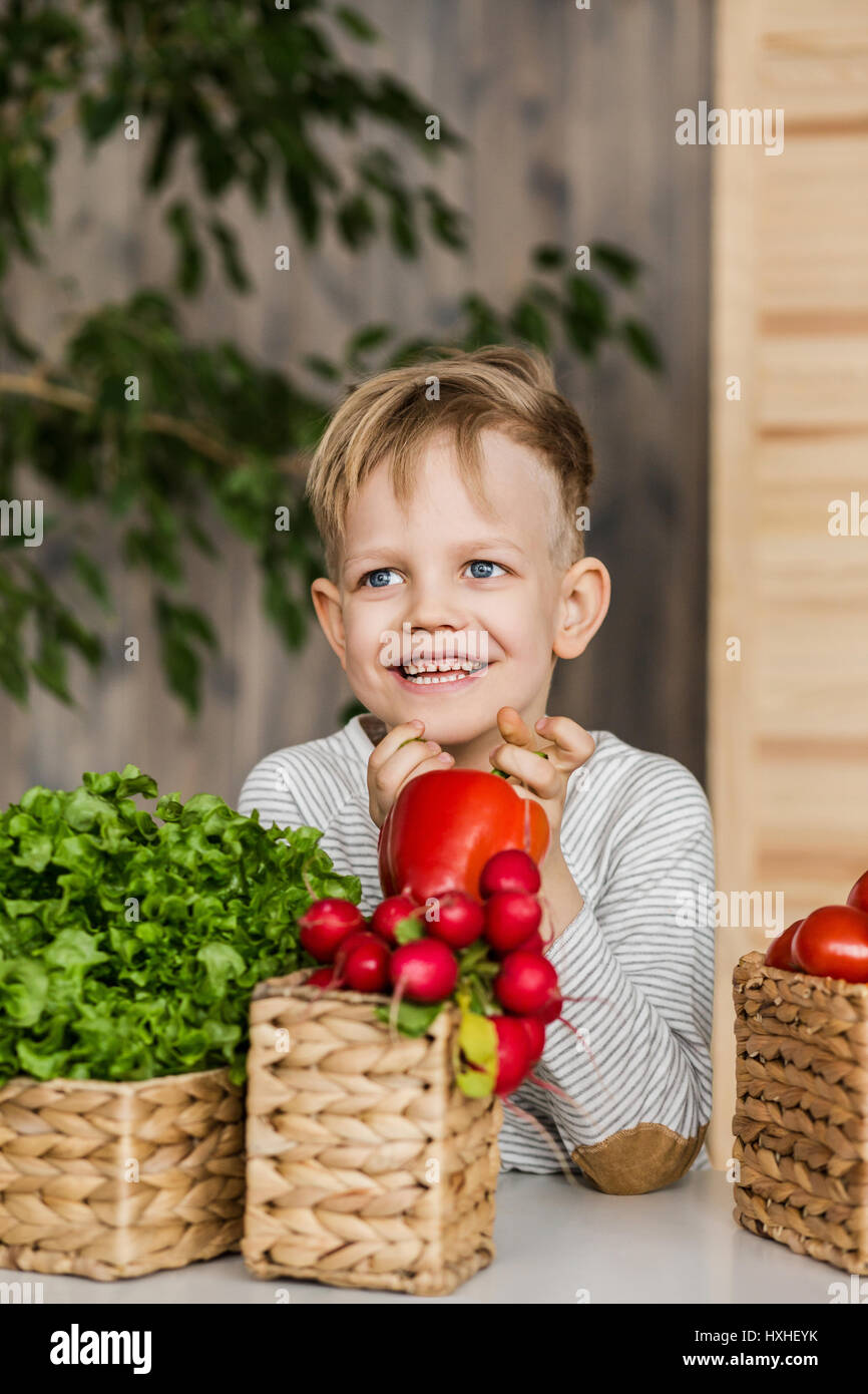 Handsome little boy in kitchen eating vegetables. Vegetarian. Healthy ...