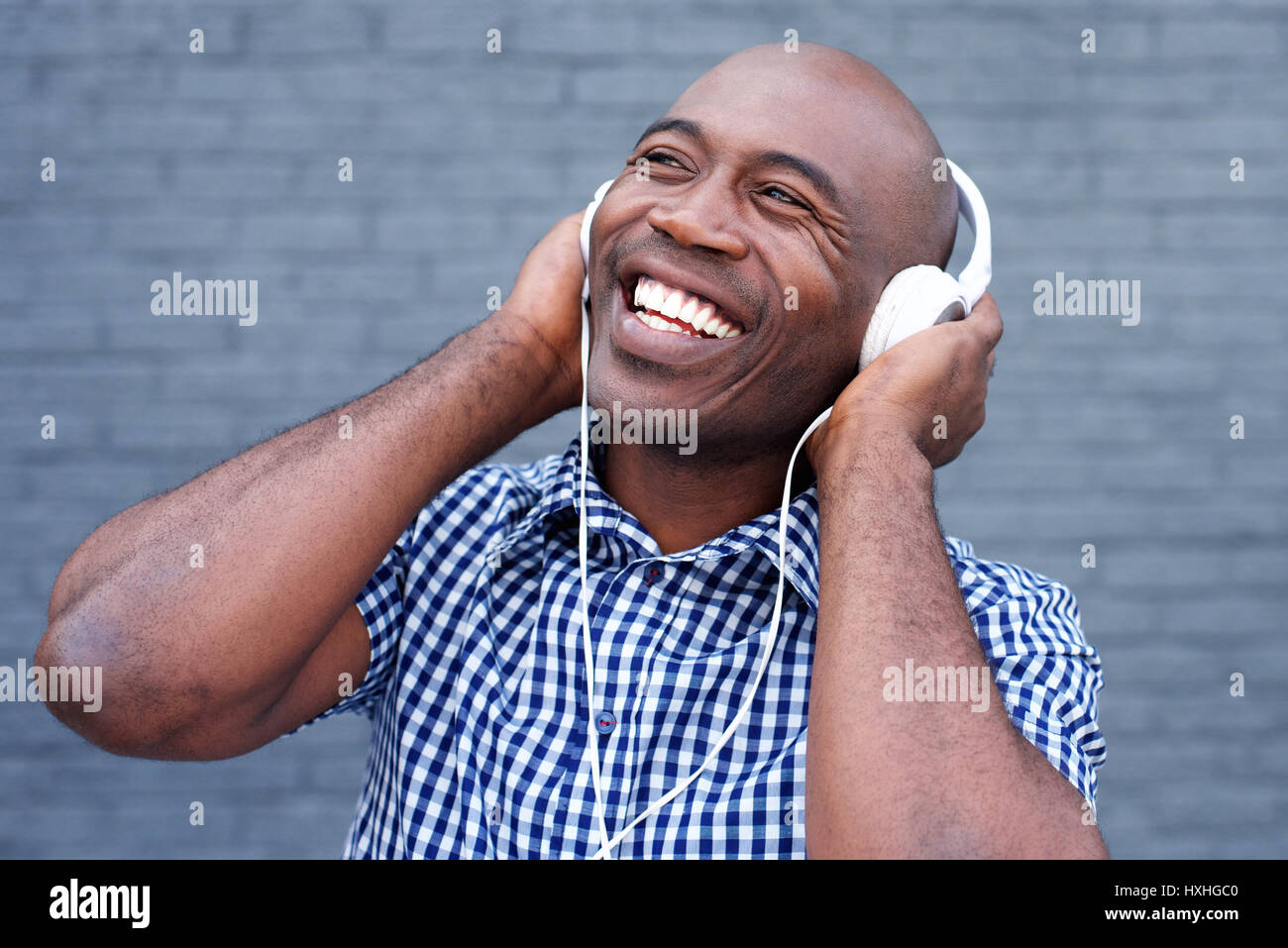 Closeup portrait of a smiling young african man listening to music on ...