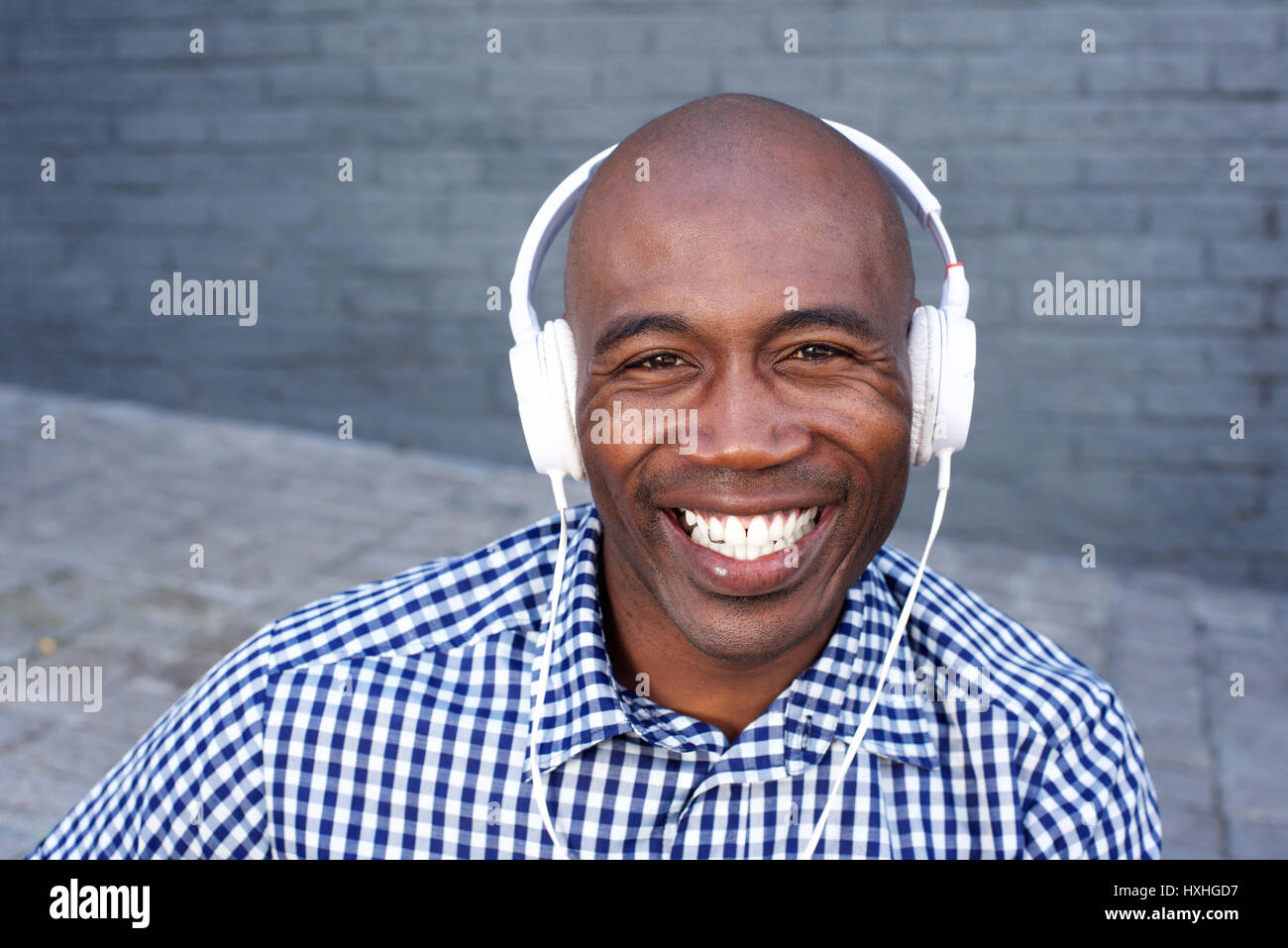 Closeup portrait of a smiling young black guy listening to music with ...