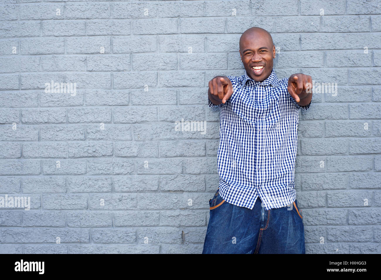 Portrait of cheerful young african man pointing finger Stock Photo - Alamy