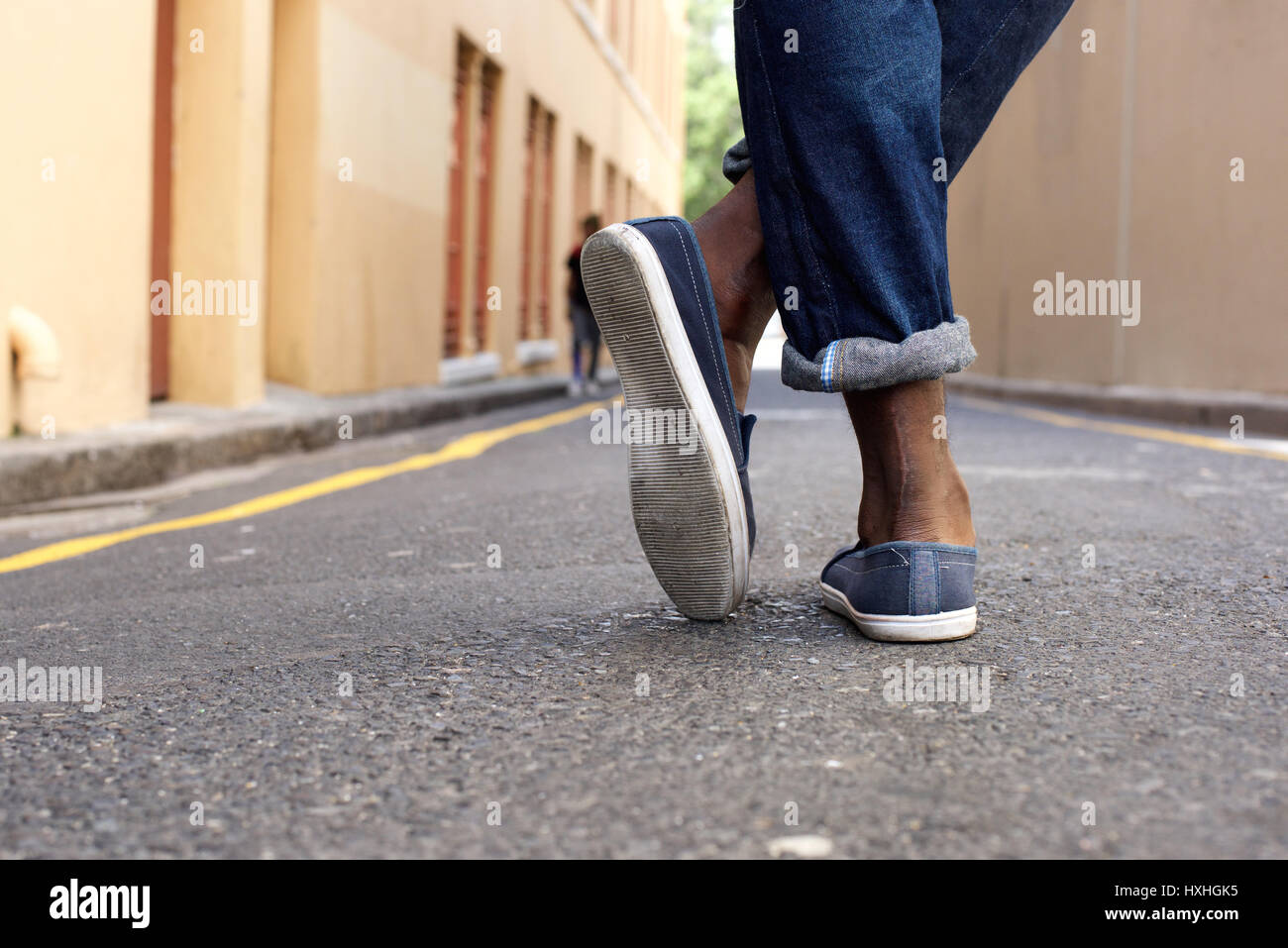 Rear view low angle man standing with crossed legs Stock Photo - Alamy