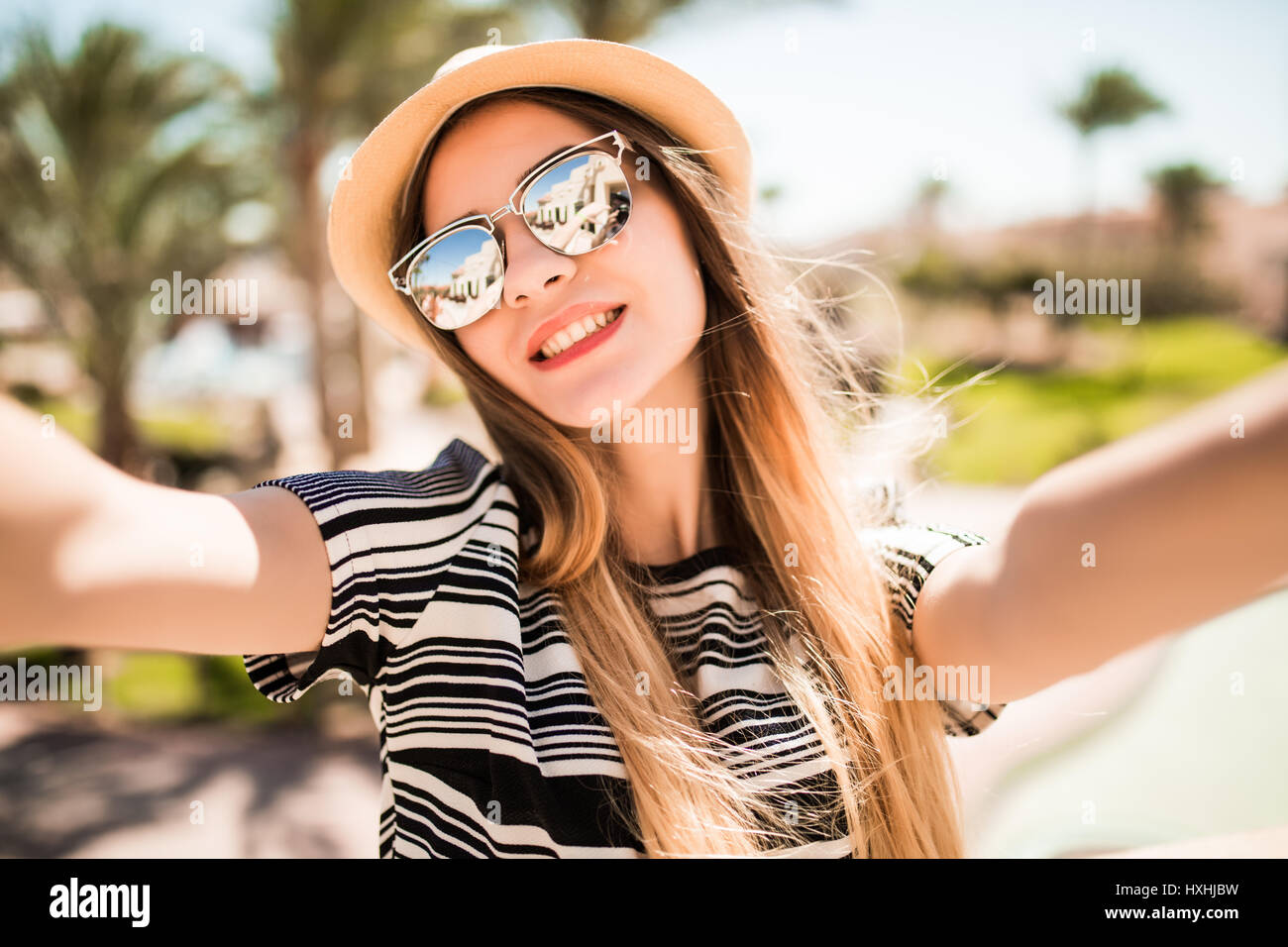 Cheerful Young Woman In Hat And Sunglasses Taking Selfie With Mobile