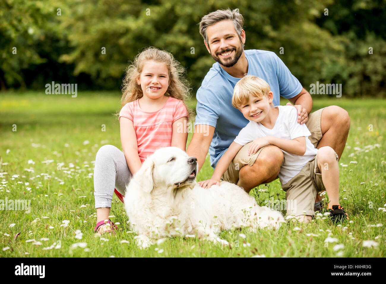 Happy family of father and children with dog together in the park Stock ...