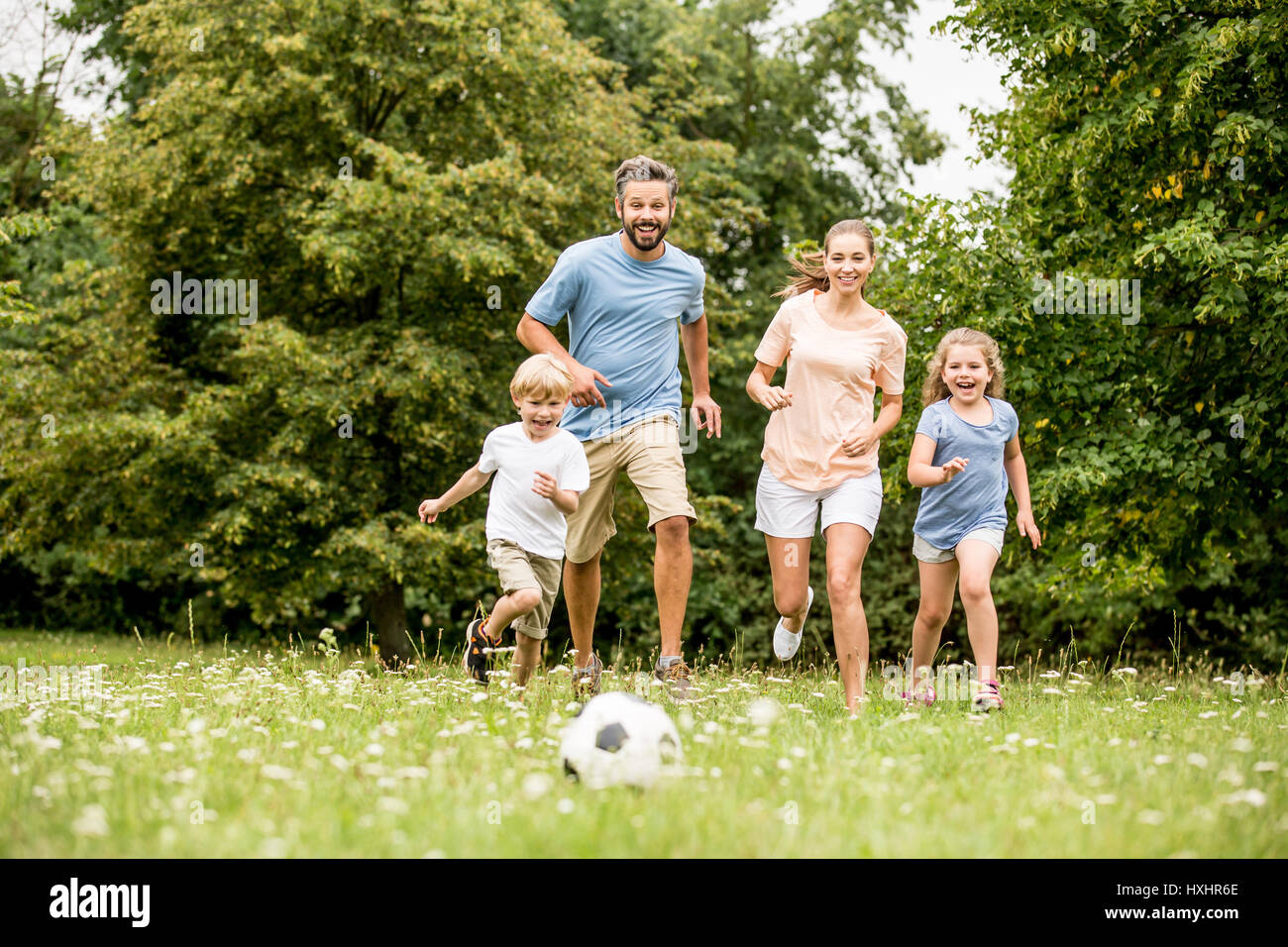 Family playing soccer in summer with their children Stock Photo - Alamy