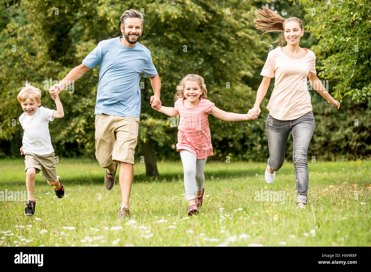 Joyful family with two children have fun running in the park Stock ...