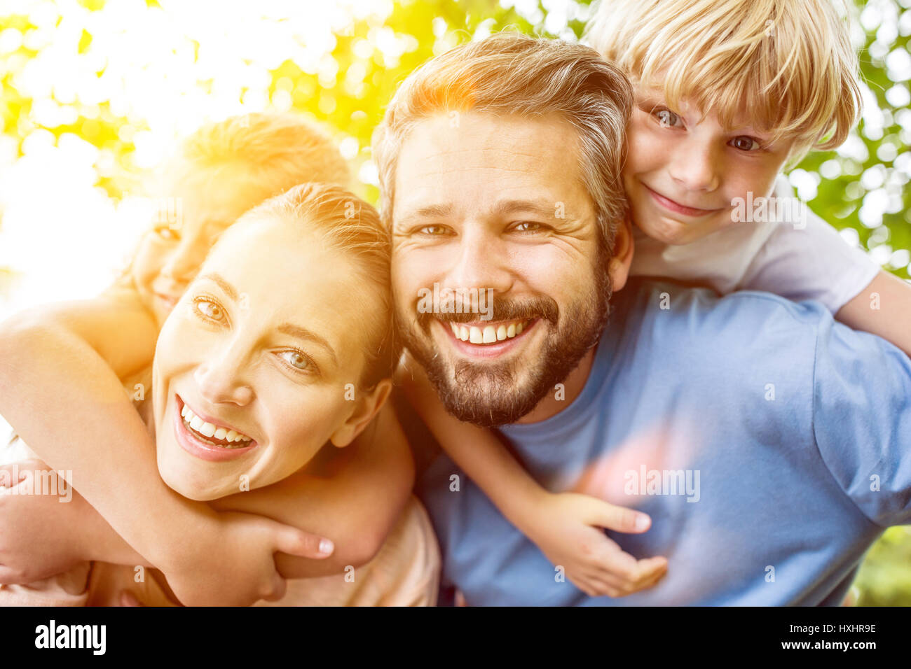 Children get piggyback ride from parents and have fun as a family Stock ...