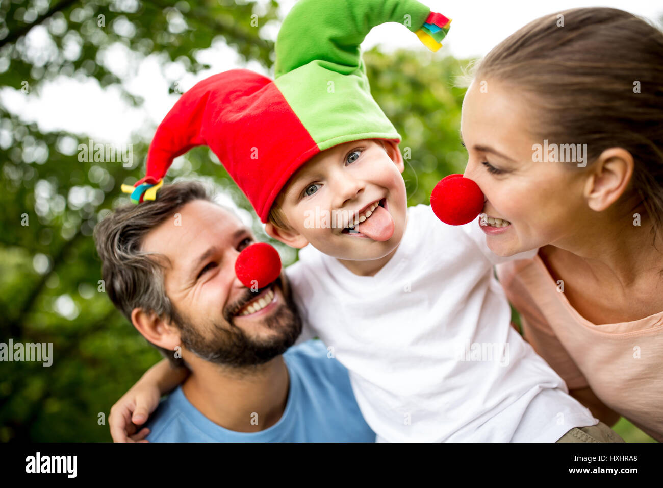 Child wearing fool cap and showing his tongue with his family Stock ...