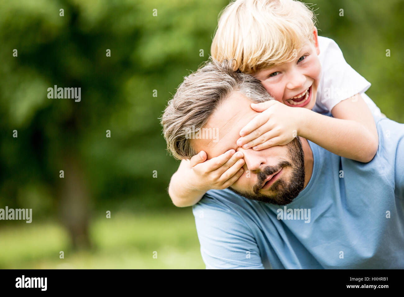 Boy plays with father and has fun laughing and covering his eyes Stock ...