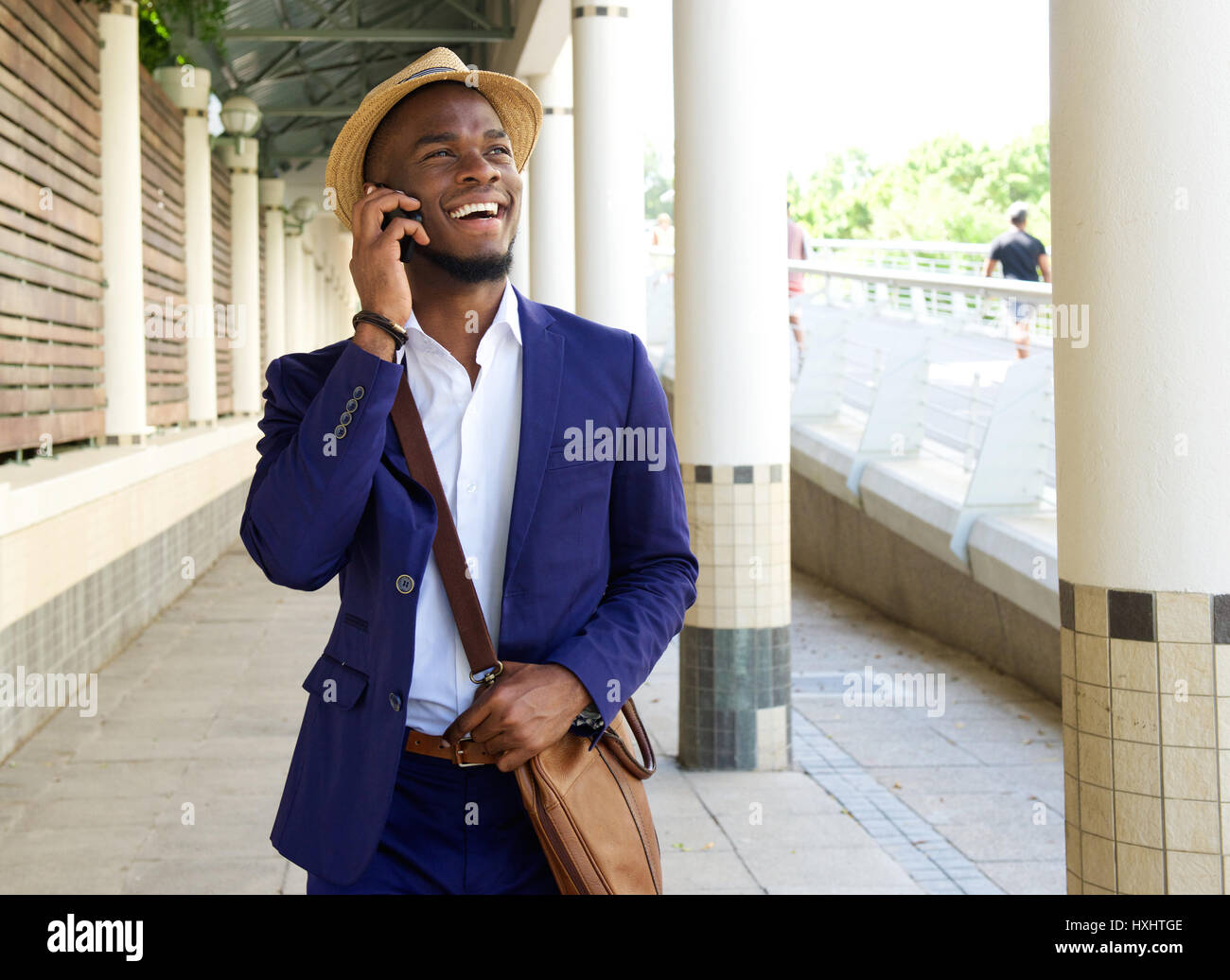 Portrait of a handsome young man walking and talking by mobile phone ...