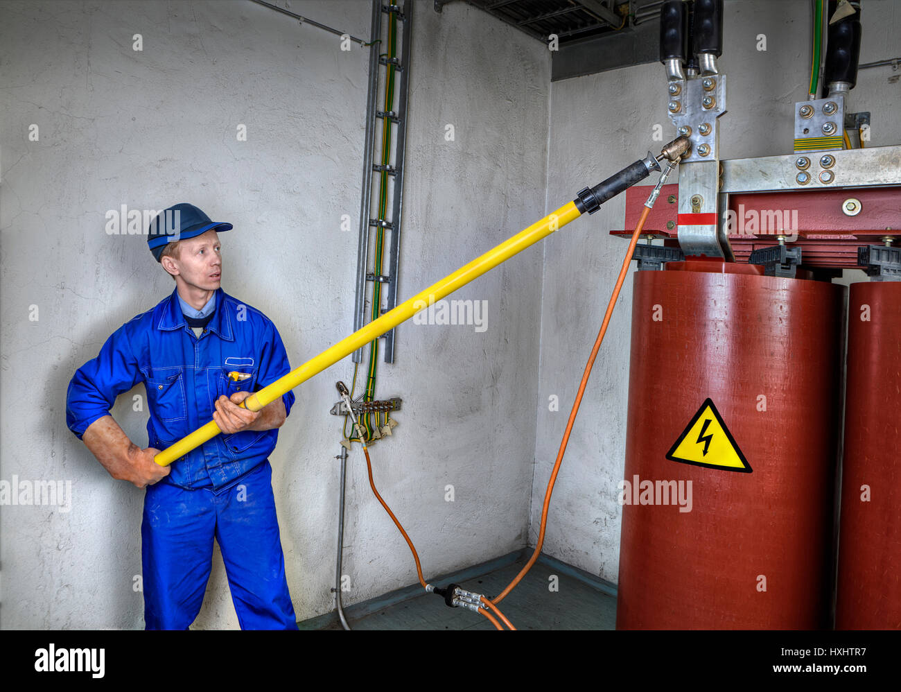 Electrician impose earth connection on reducing power transformer, to ...