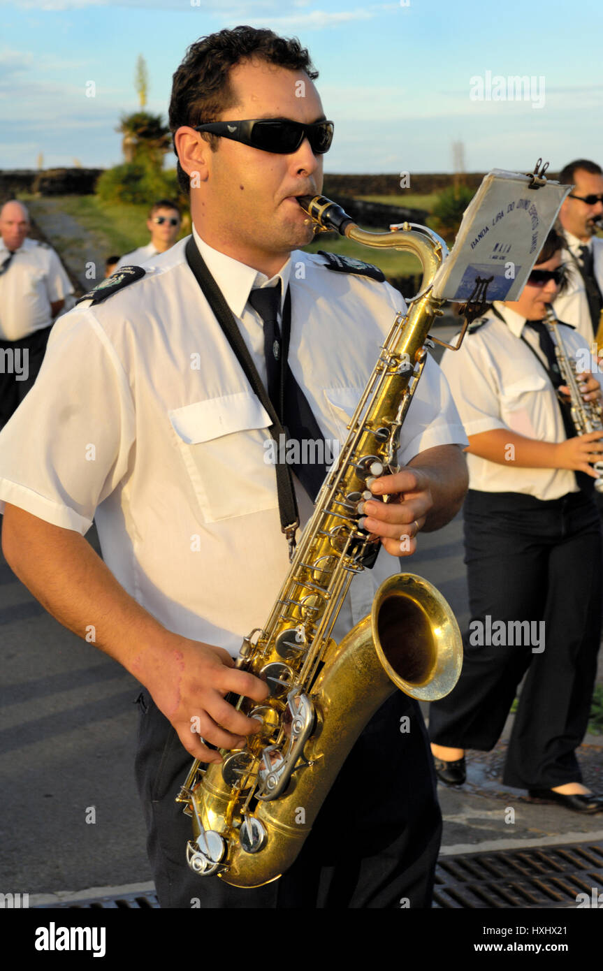 Man in marching brass band playing saxophone at religious procession in ...