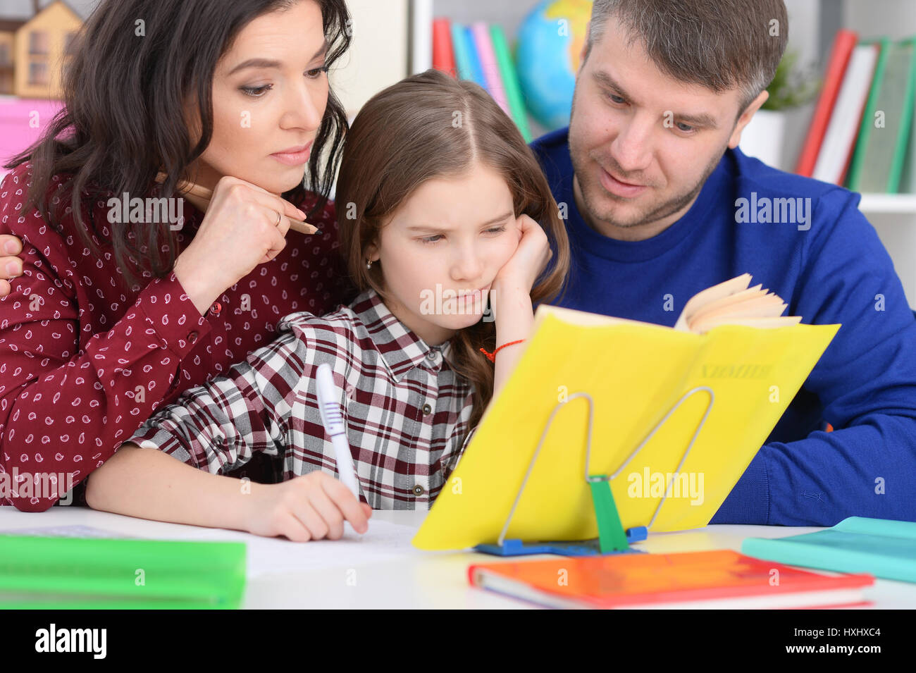 Parents helping daughter with lessons Stock Photo - Alamy