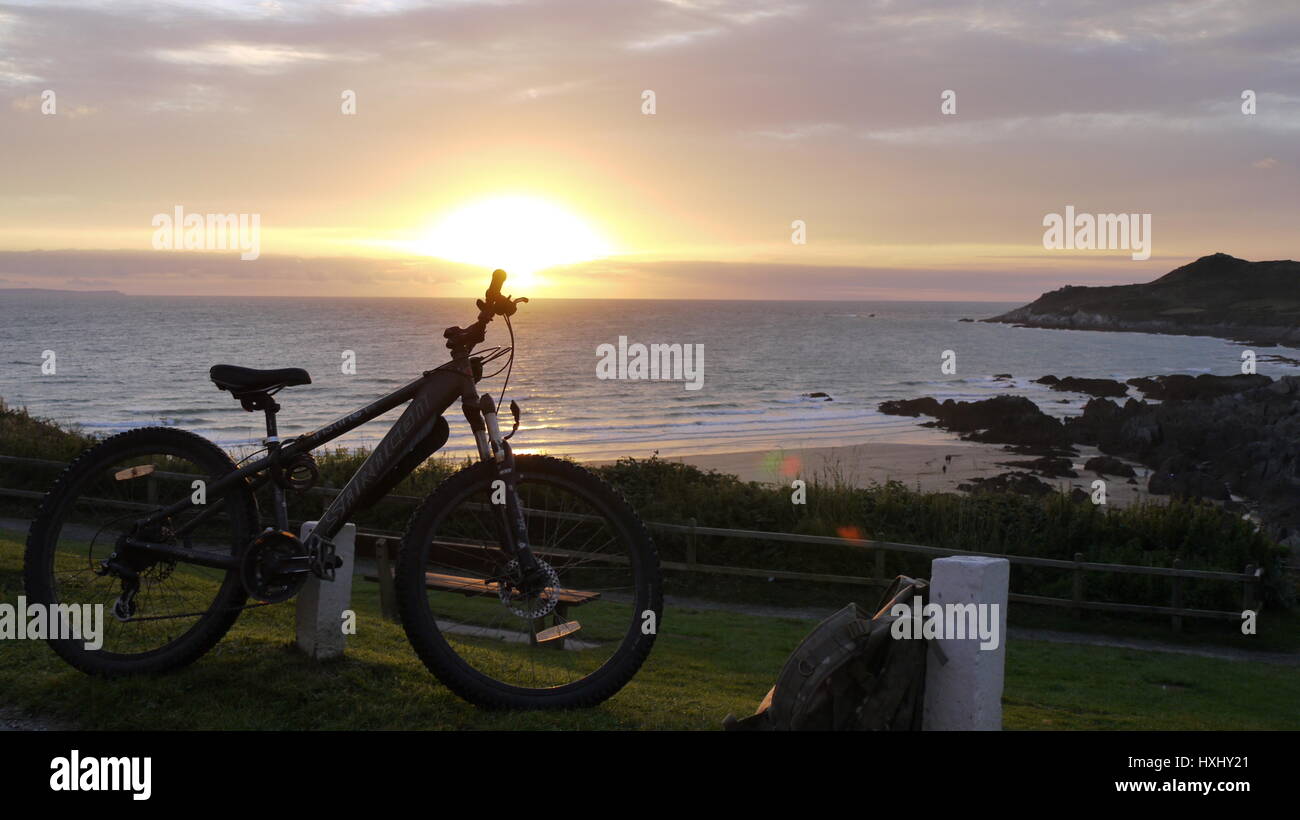 Bike resting on railings in front of sunset at beach Stock Photo - Alamy