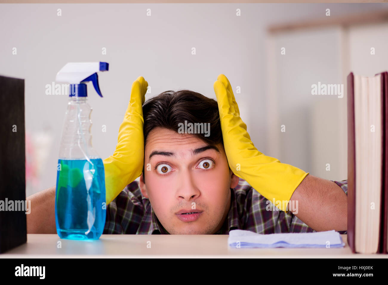 Man cleaning dust from bookshelf Stock Photo - Alamy