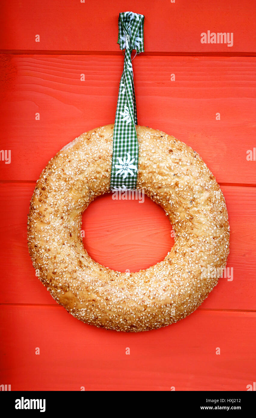 A beautiful round bread on a red background photographed in close-up ...
