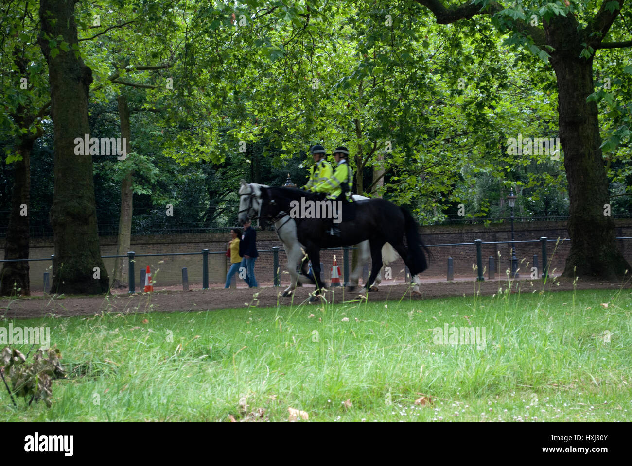Two police officers on horseback ride past Hyde Park in London beneath ...