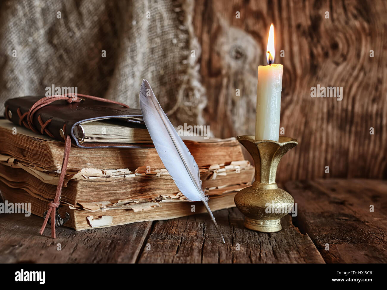 feather and book novel close to the a candle Stock Photo - Alamy